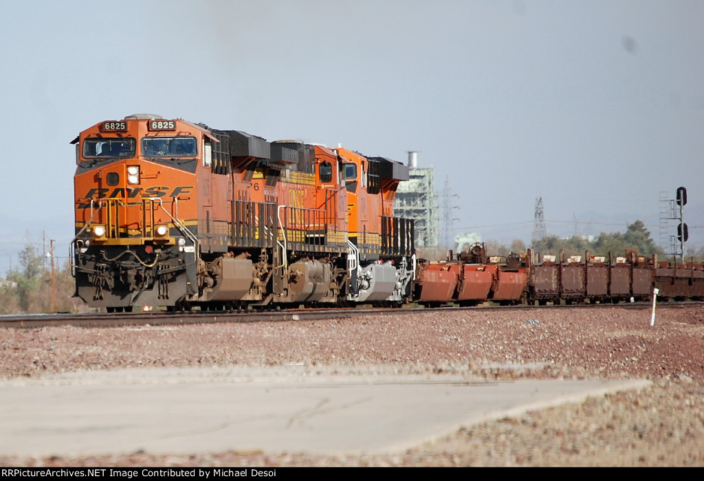 BNSF ES-44C4 #6825 leads a westbound baretable train through the signals